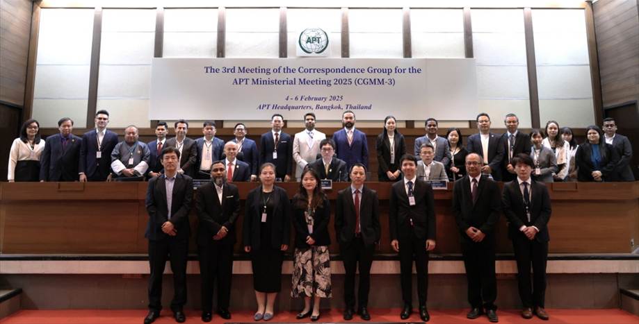 A group of people standing in front of a wallDescription automatically ...